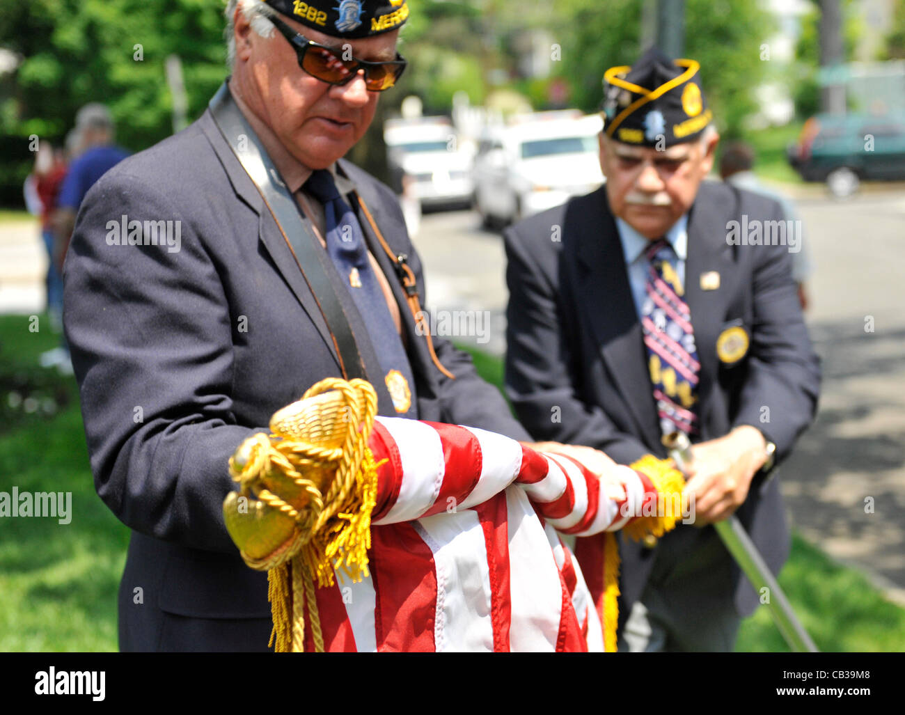 American Legion members carefully roll up flags after the Merrick ...