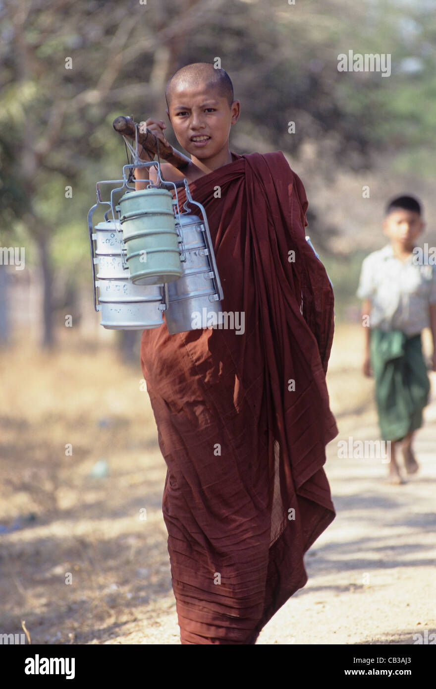 Young Buddhist Monk walking road with lunch boxes for alms, Magwe ...