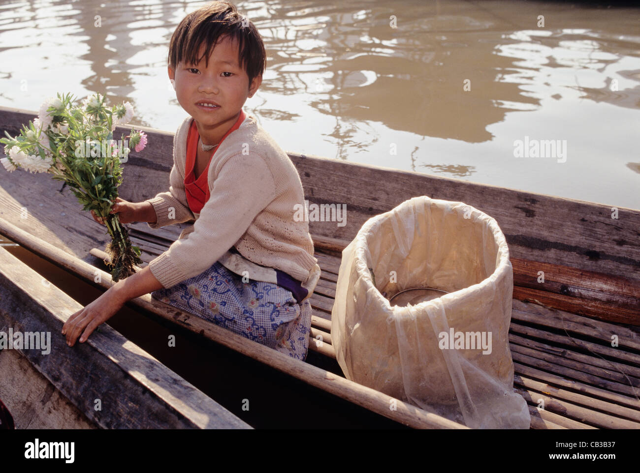 Inle Lake floating market scene, girl selling flowers from boat at ...