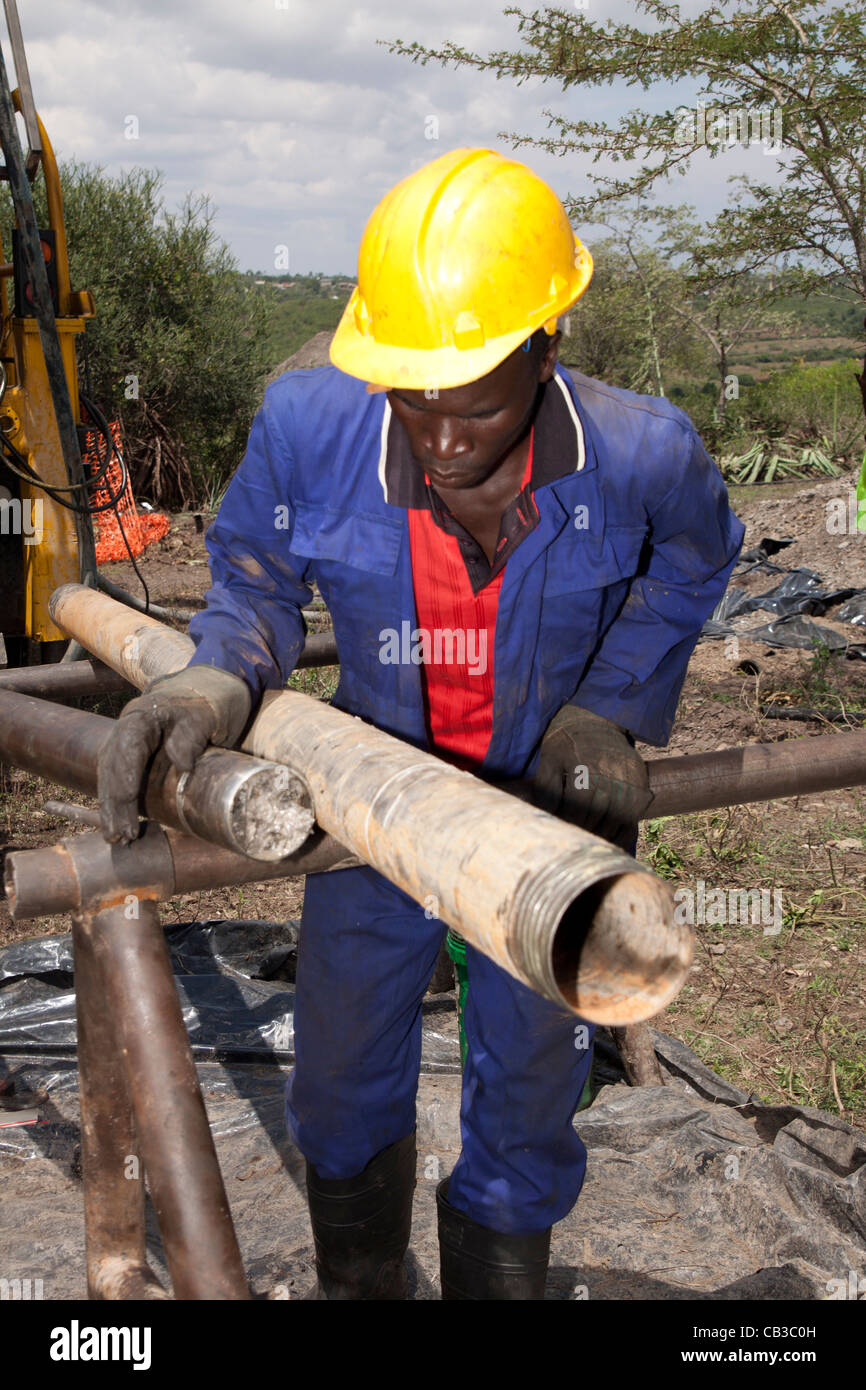 Tandrill employees changing diamond drill rod on multipurpose drill rig ...
