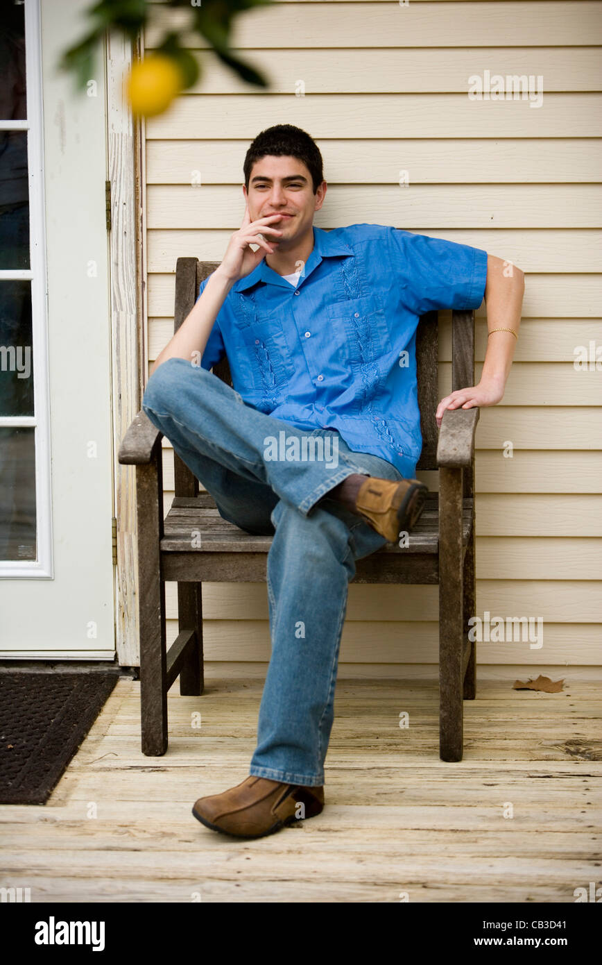 Young Mexican-American man sitting on porch Stock Photo - Alamy