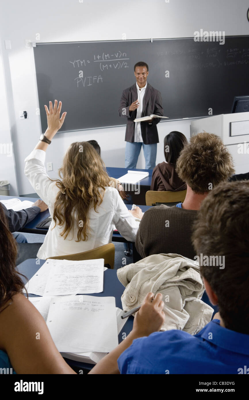 Student raising hand in the classroom Stock Photo - Alamy
