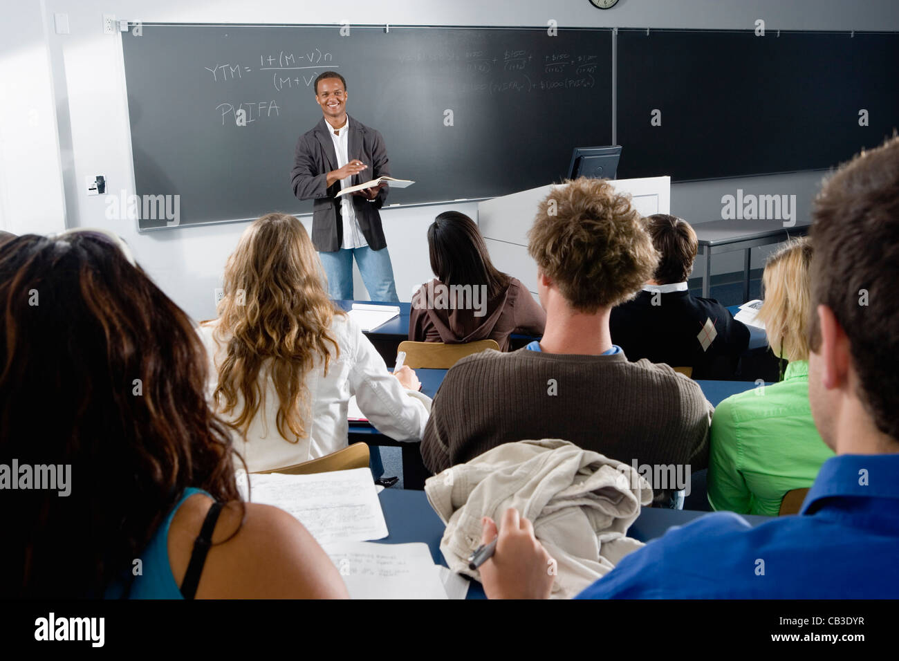 Teacher teaching students in the classroom Stock Photo - Alamy