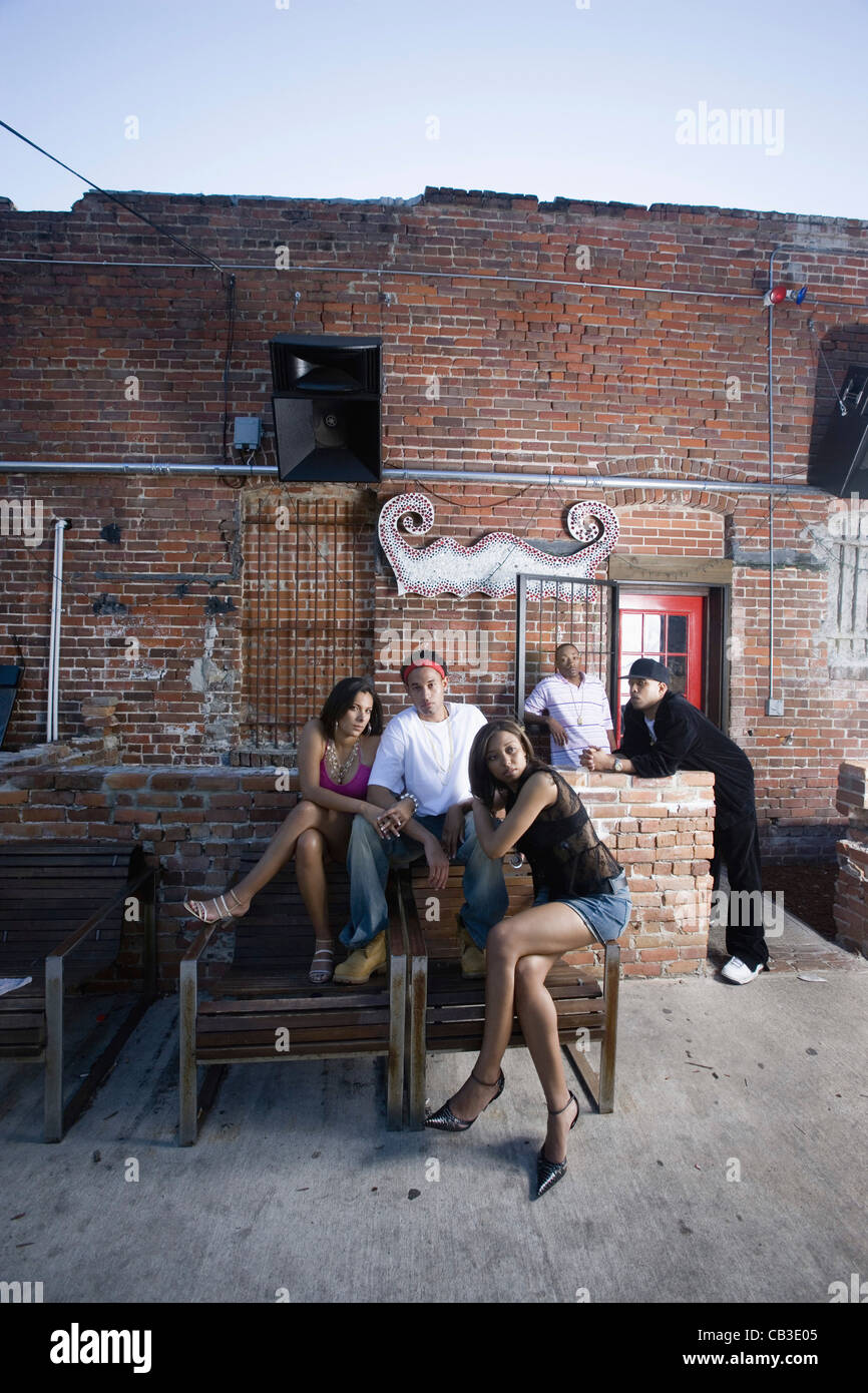 Portrait of young men and women in hip-hop fashion hanging out in a ...