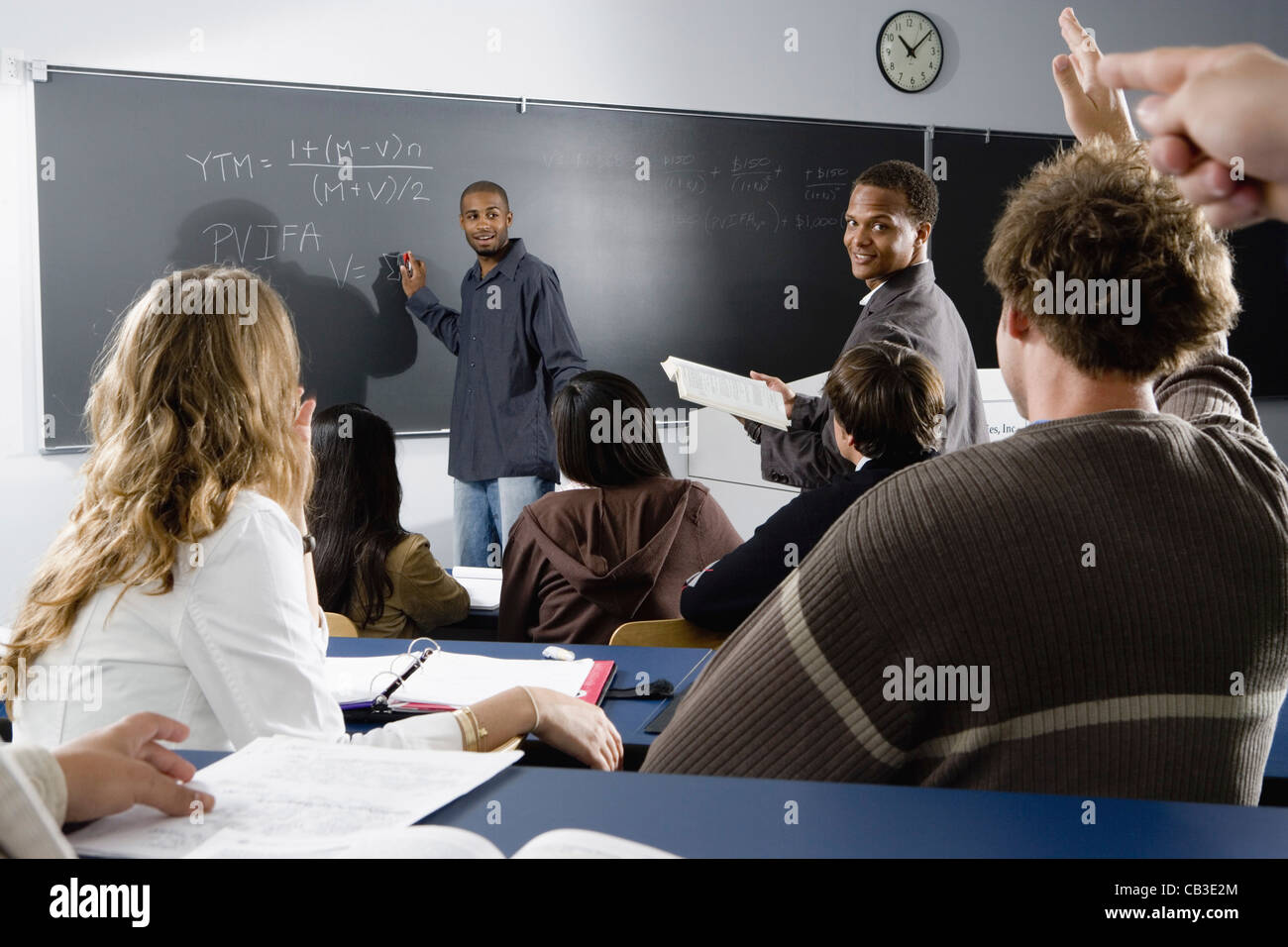 Teacher teaching students in the classroom Stock Photo - Alamy