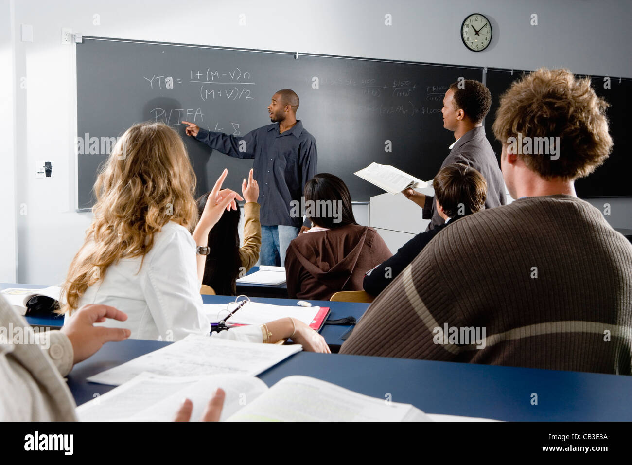 Teacher teaching students in the classroom Stock Photo - Alamy