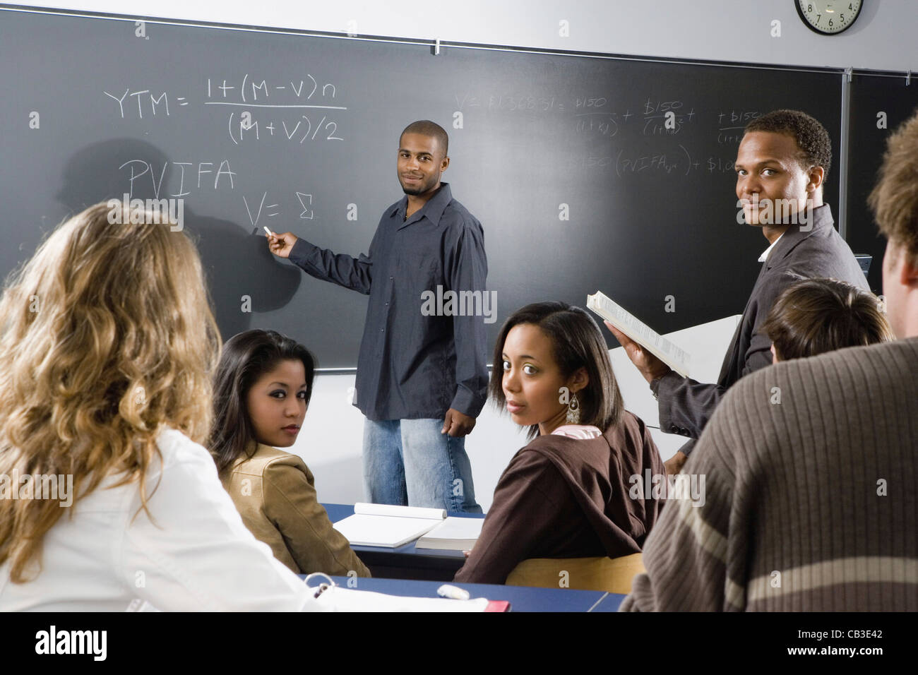 Teacher teaching students in the classroom Stock Photo - Alamy