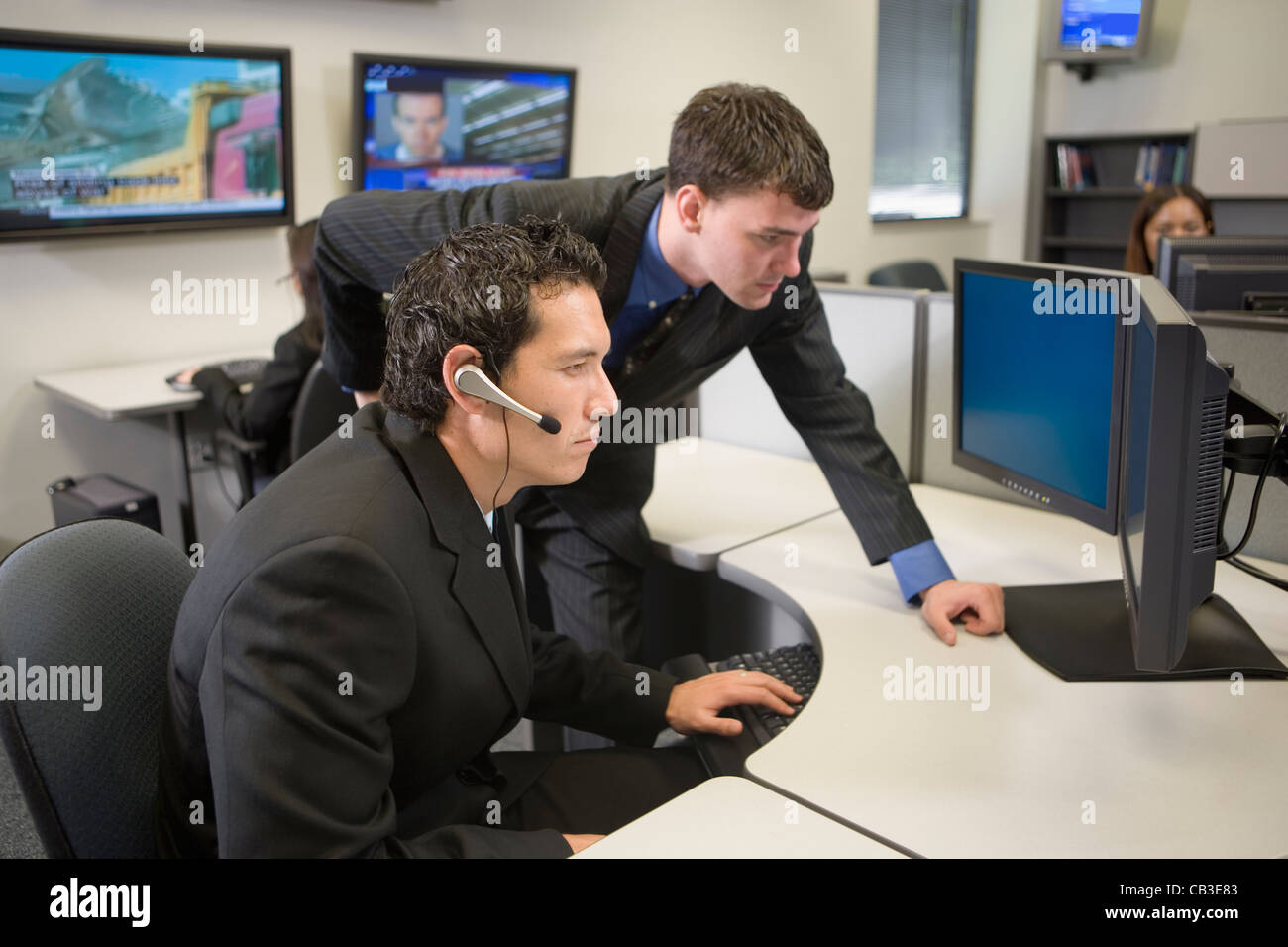 Co-workers in an office looking at a computer screen Stock Photo - Alamy