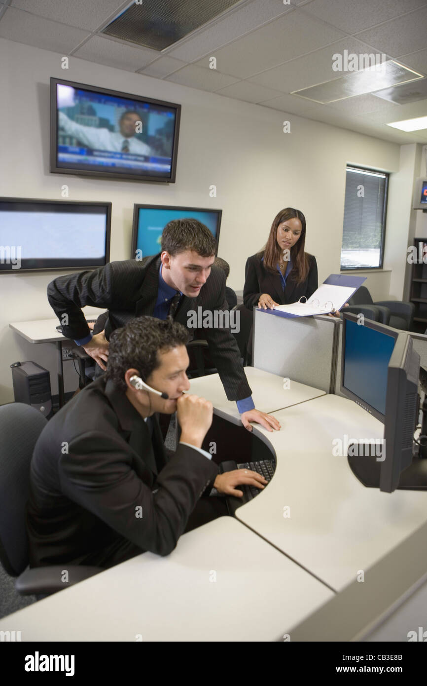 Co-workers in an office looking at a computer screen Stock Photo - Alamy