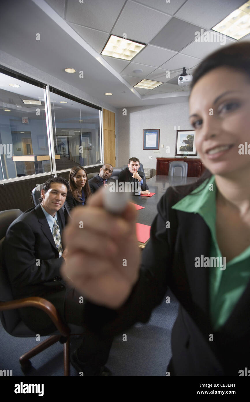 Business men and women at a presentation in a formal conference room ...