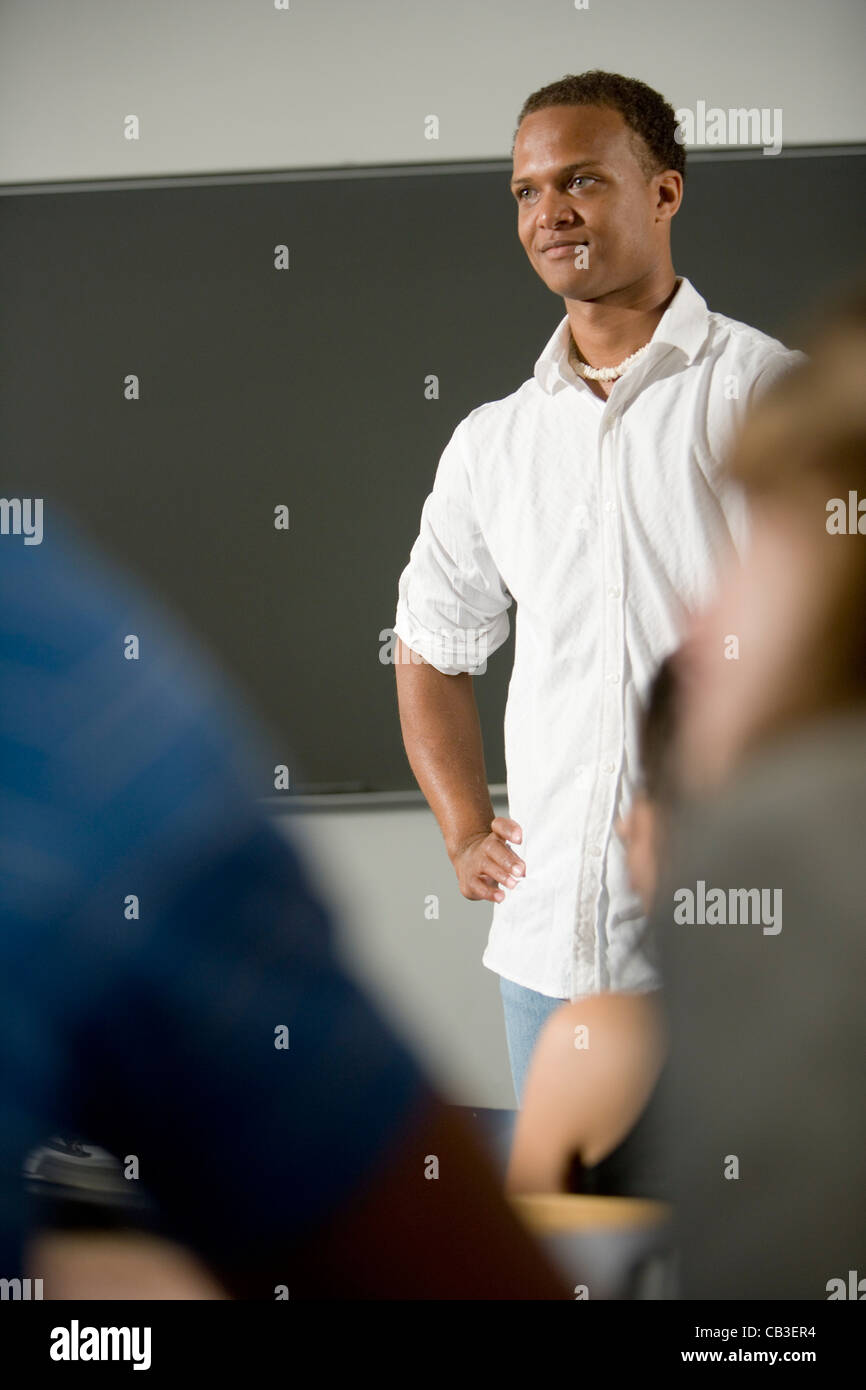 Teacher standing in the classroom Stock Photo - Alamy