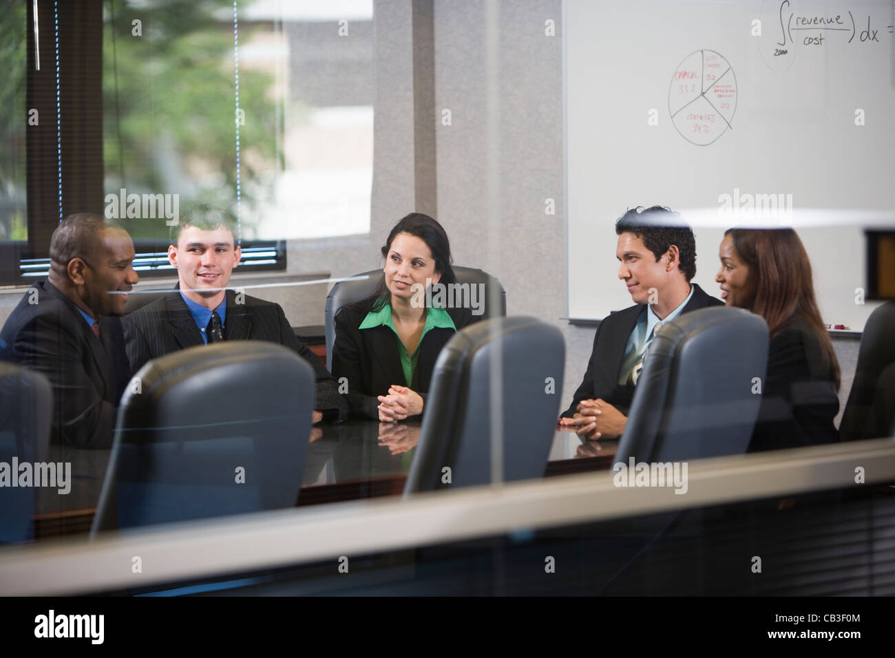 Business executives meeting in a conference room viewed through a ...