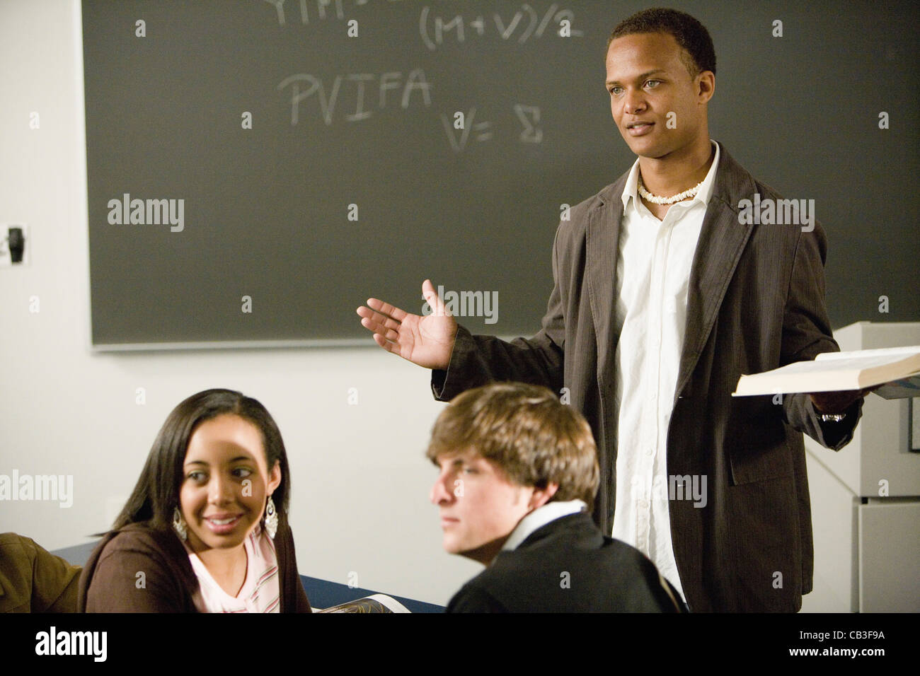 Teacher gesturing to students in the classroom Stock Photo - Alamy