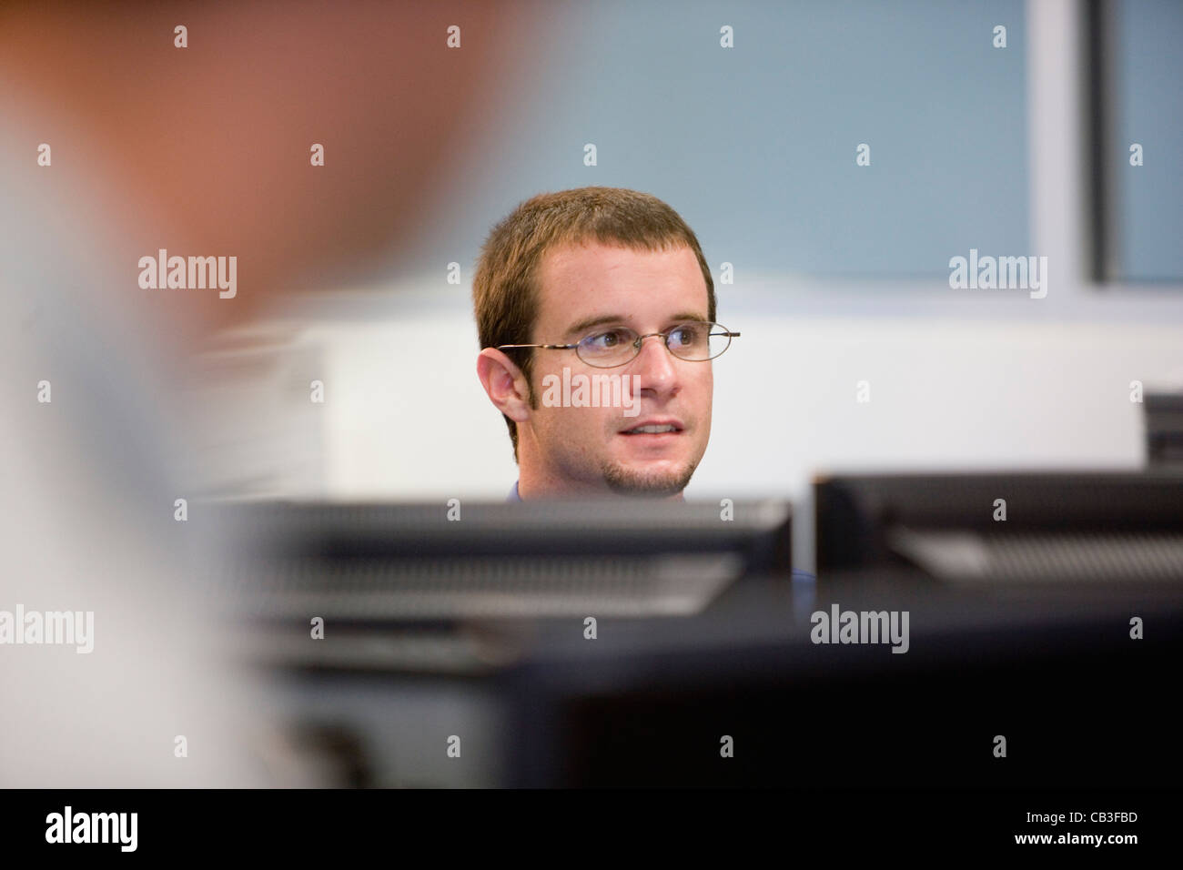 Young man behind computer monitors Stock Photo - Alamy