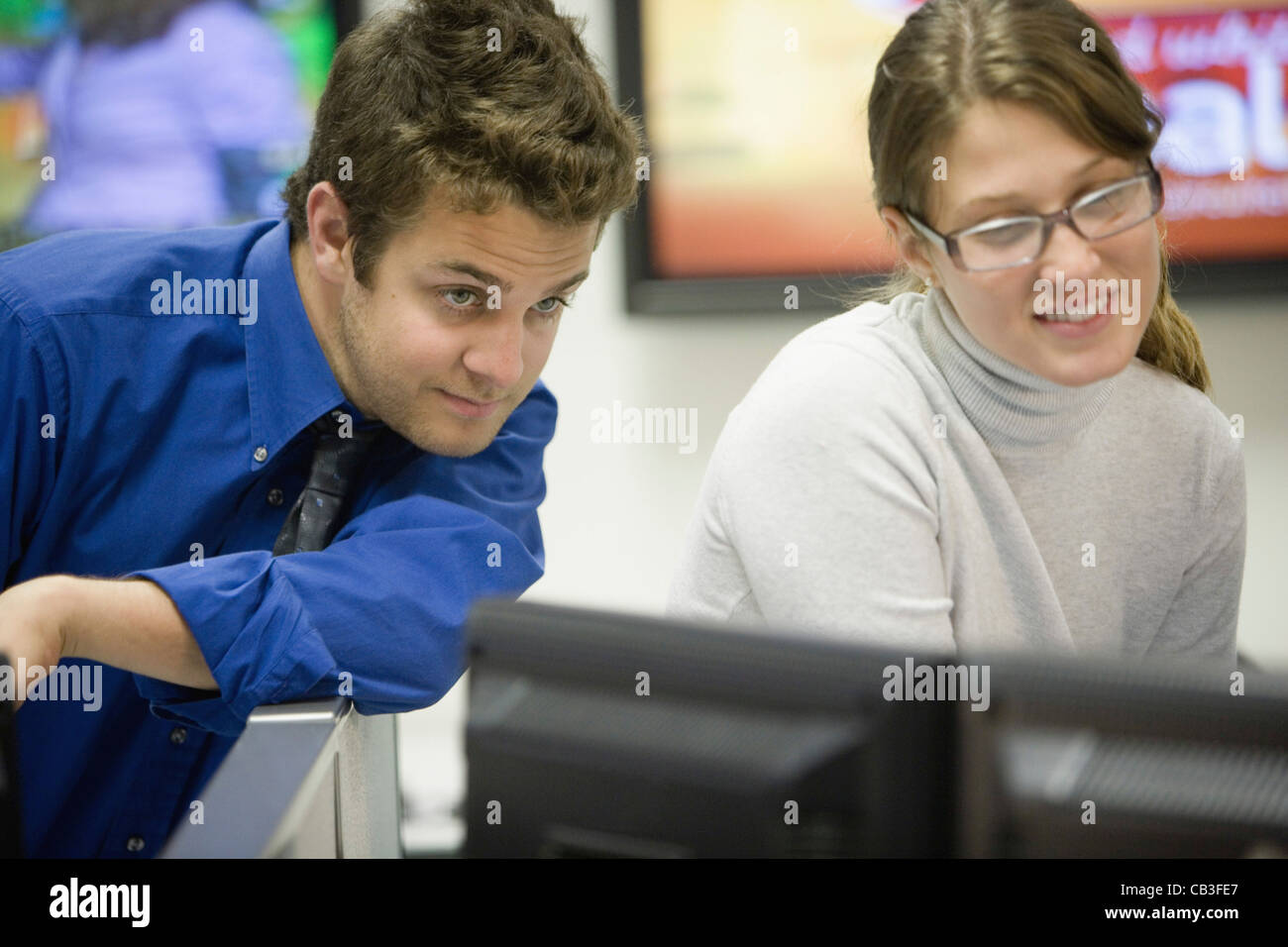 Co-workers looking at computer monitor Stock Photo - Alamy