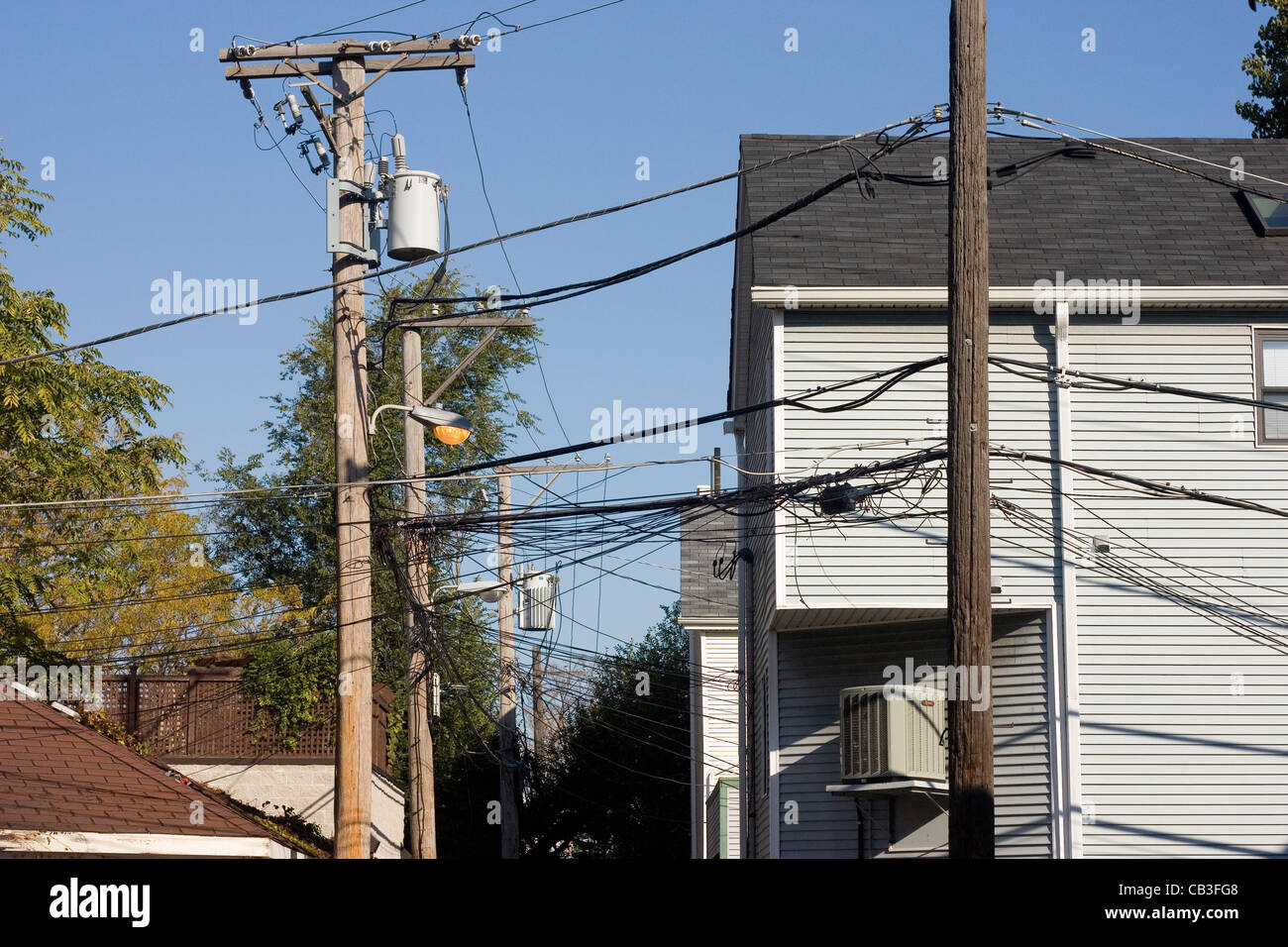 A confusion of power lines in an urban back alley Stock Photo - Alamy