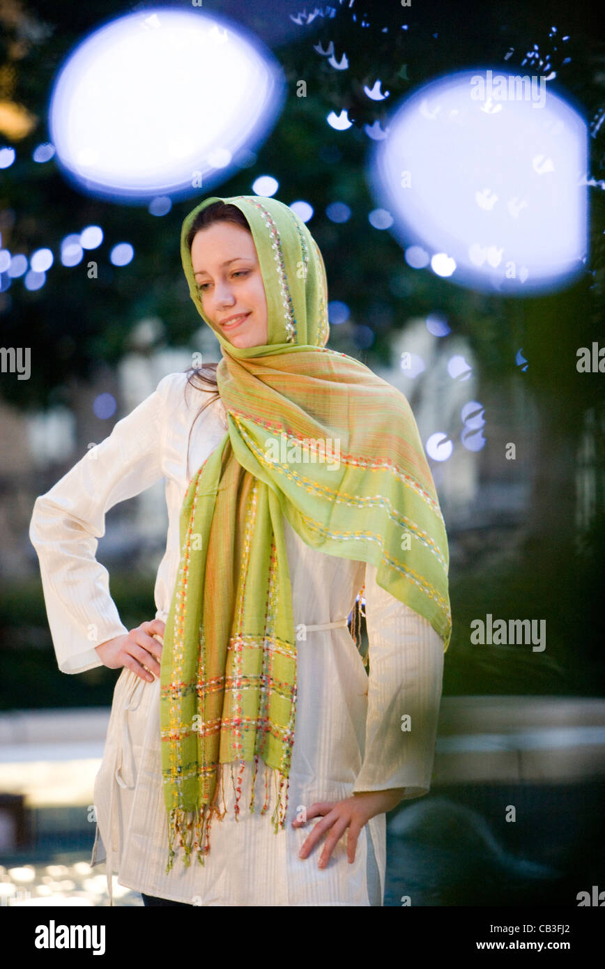 Young woman wearing a head scarf standing in a garden Stock Photo - Alamy