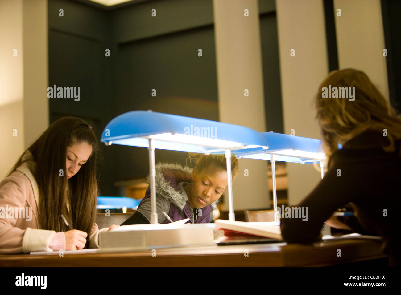 Three young women studying in the reading room of a library Stock Photo ...
