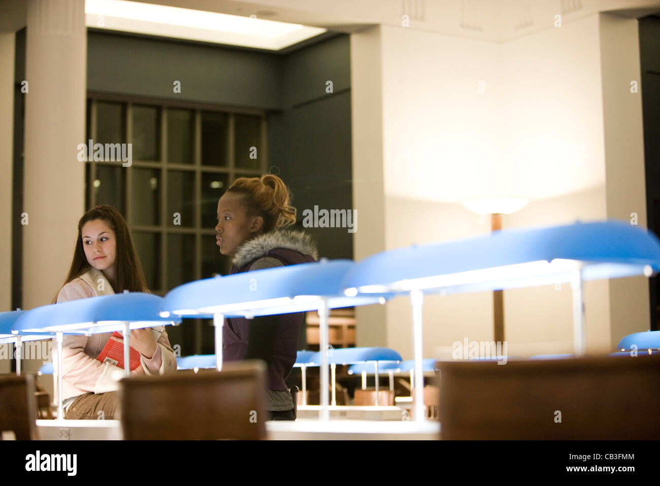 Two young women sitting in the reading room of a library Stock Photo ...