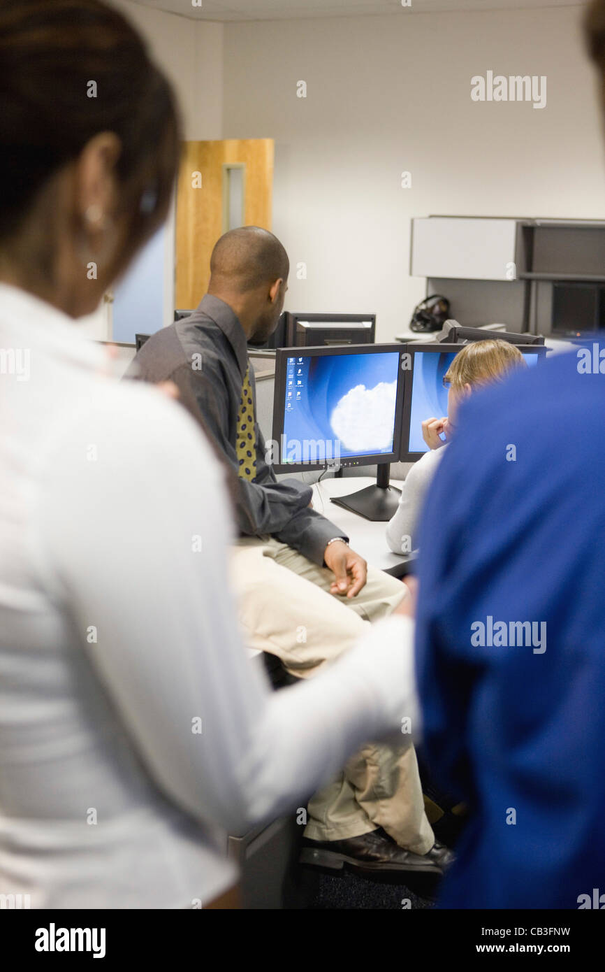 Office workers looking at computer screen Stock Photo - Alamy