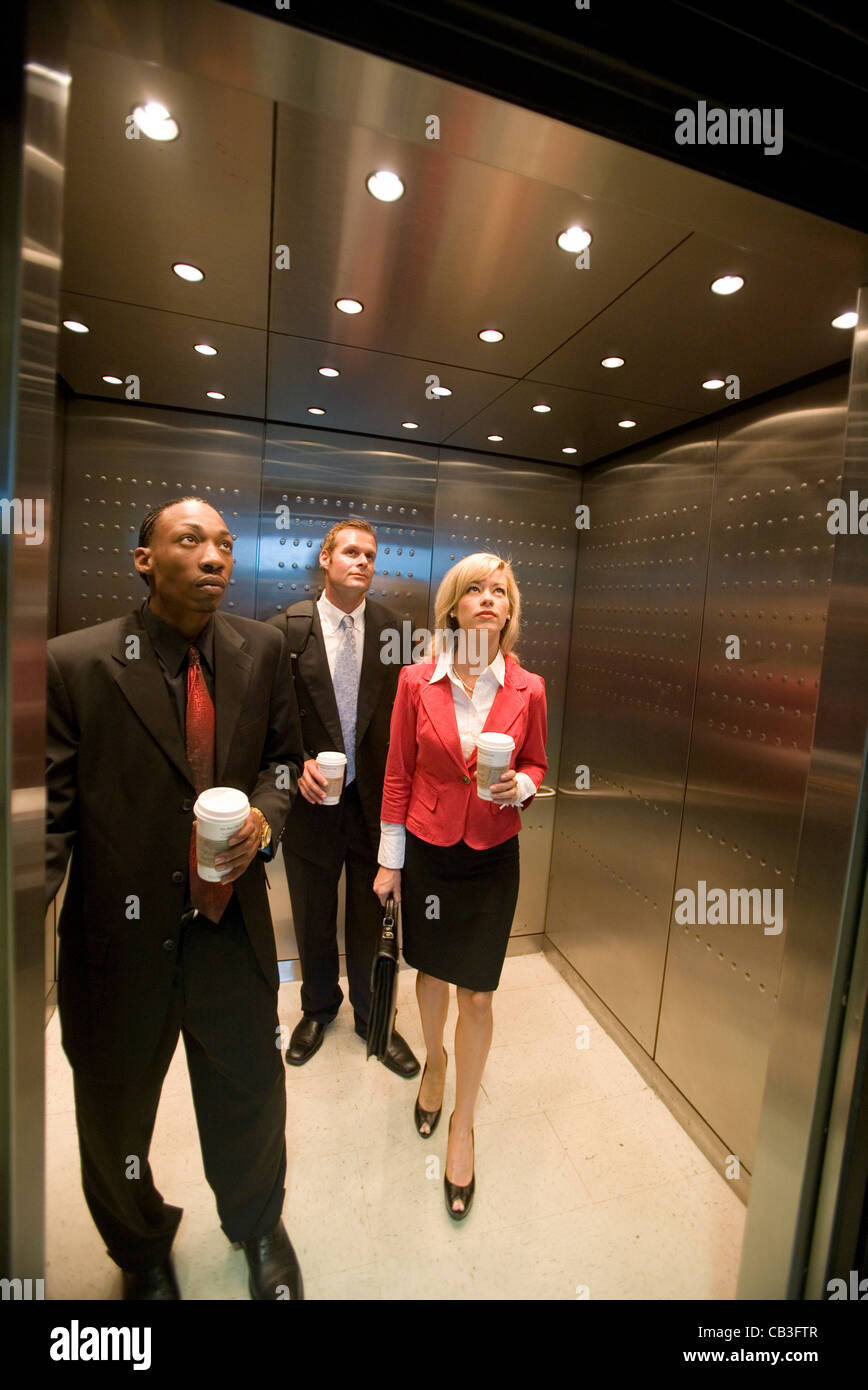 Portrait of business people riding in an elevator Stock Photo - Alamy