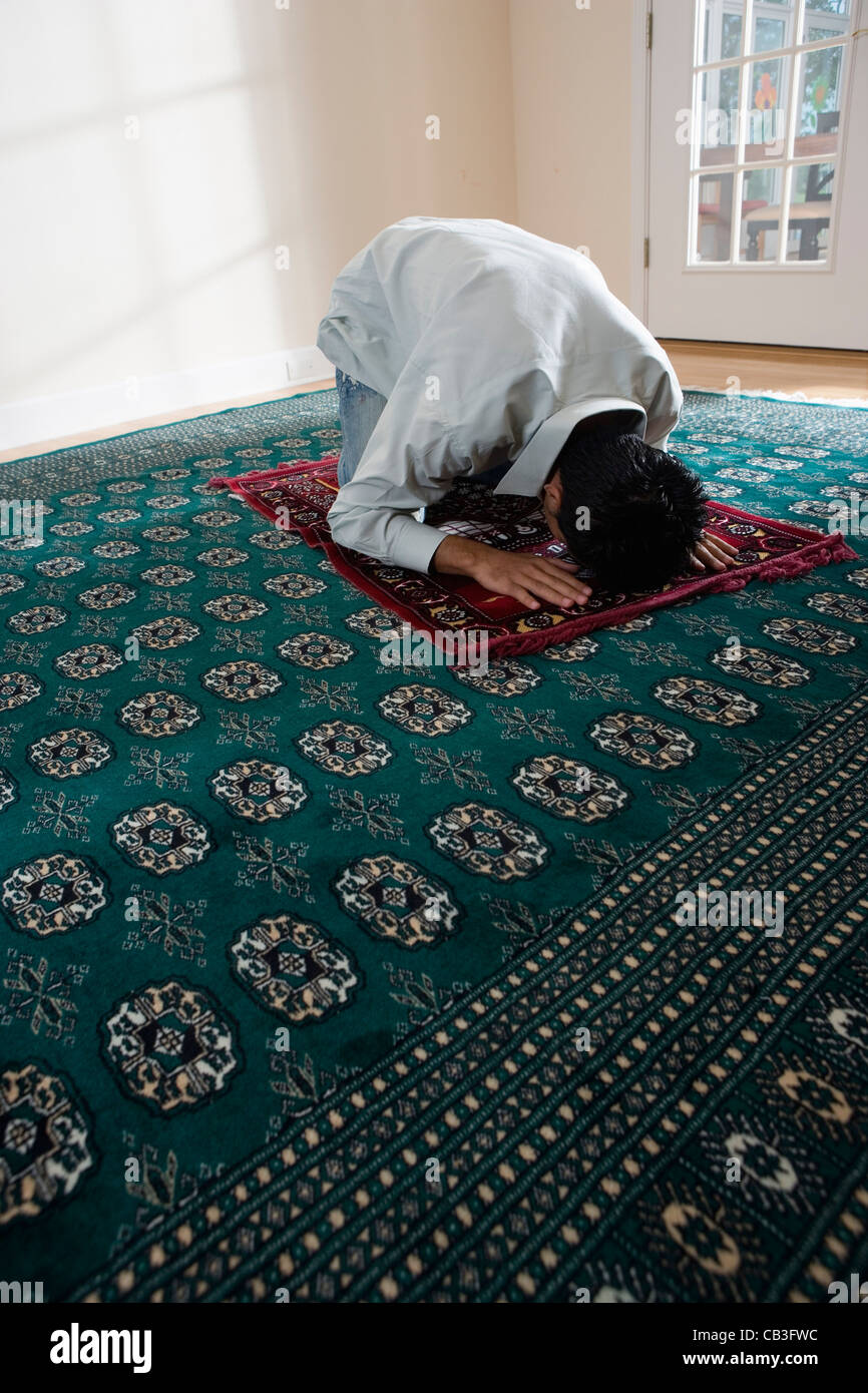 A Muslim man bowing head on a prayer mat Stock Photo - Alamy