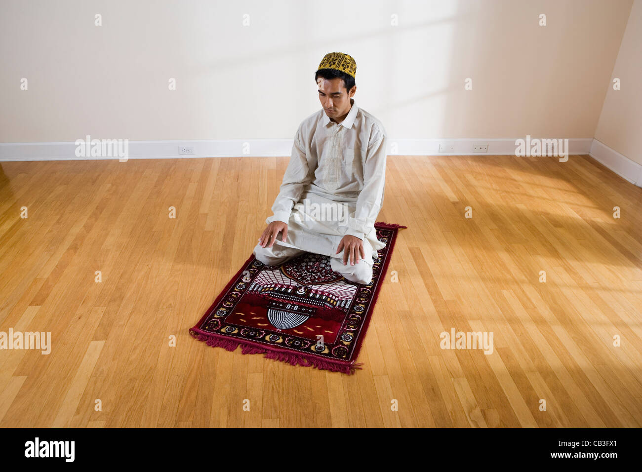 A Muslim man praying on a prayer mat Stock Photo - Alamy