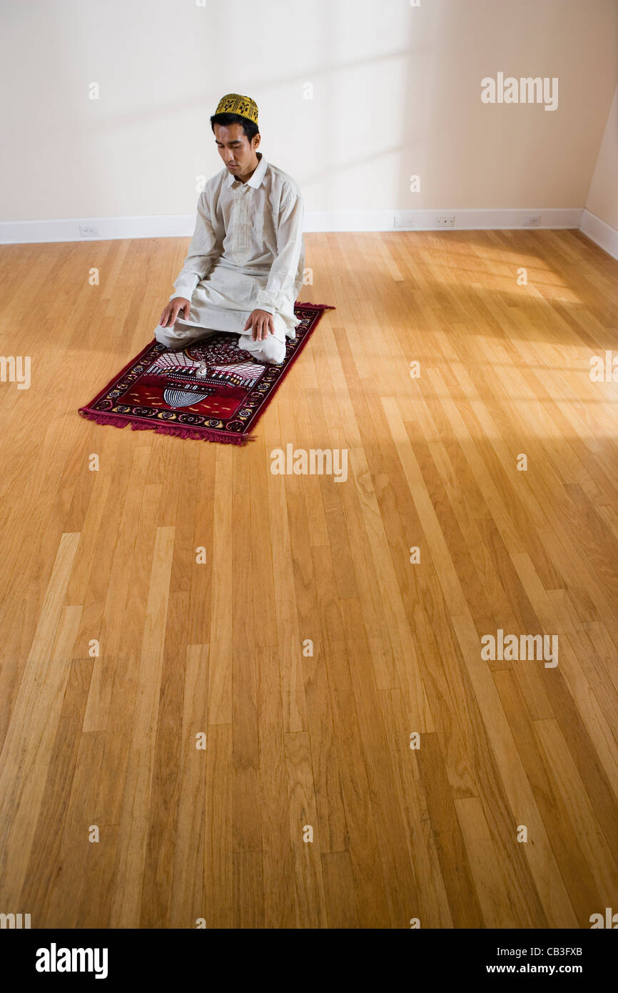 A Muslim man praying on a prayer mat Stock Photo - Alamy
