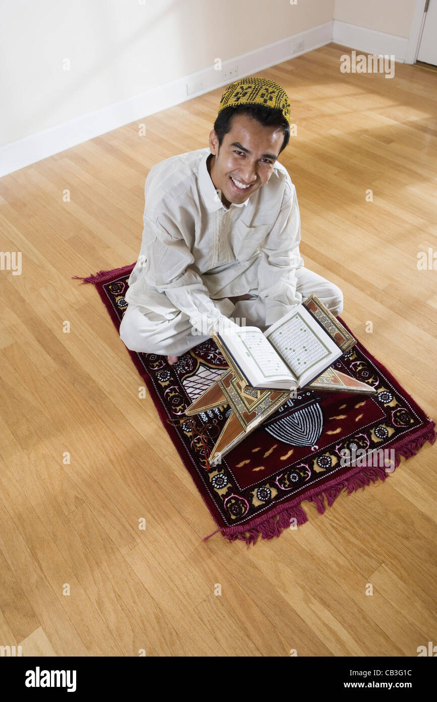 Portrait of a Muslim man sitting on a prayer mat Stock Photo - Alamy