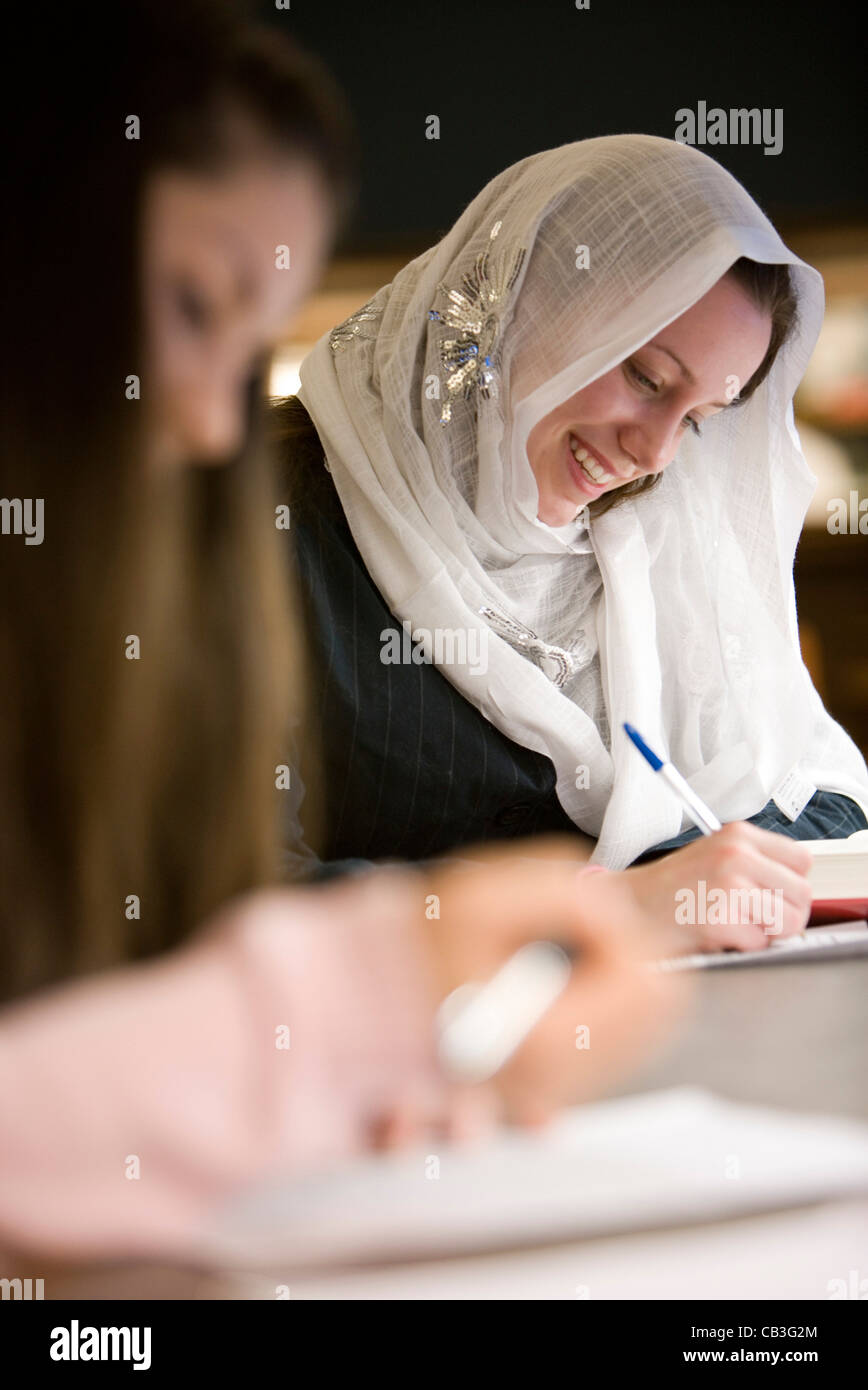 Close up of two women writing Stock Photo - Alamy
