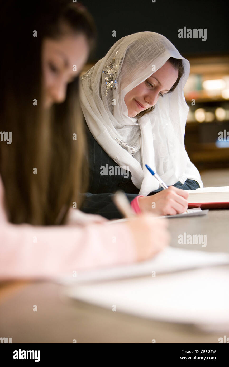 Close up of two women writing Stock Photo - Alamy
