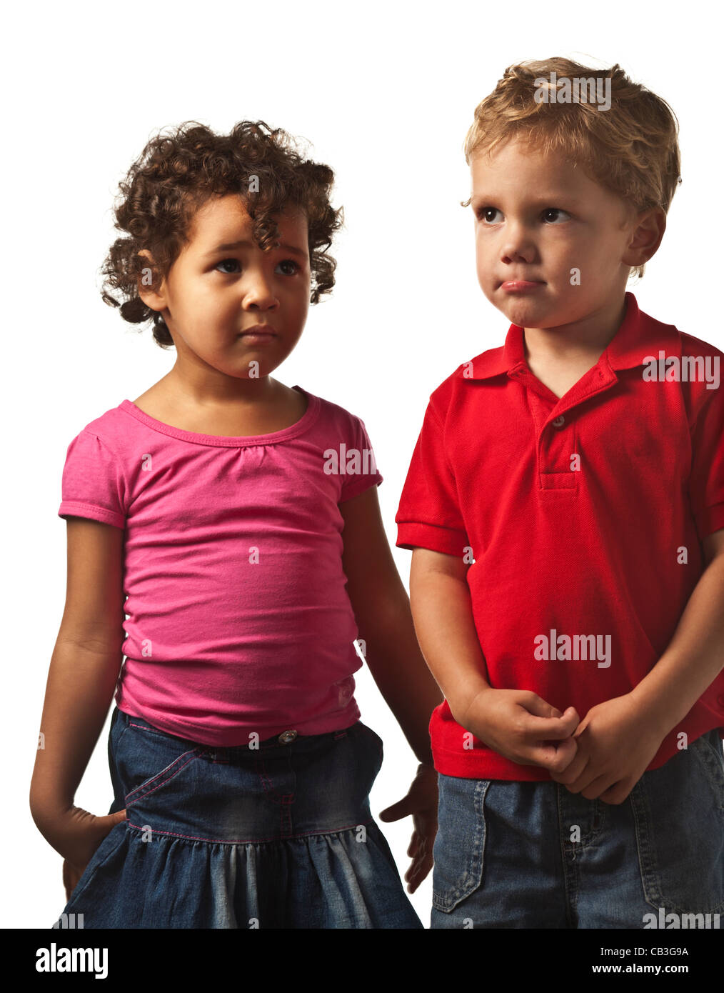 Two ethnically diverse kids looking forlorn after being chastised for ...