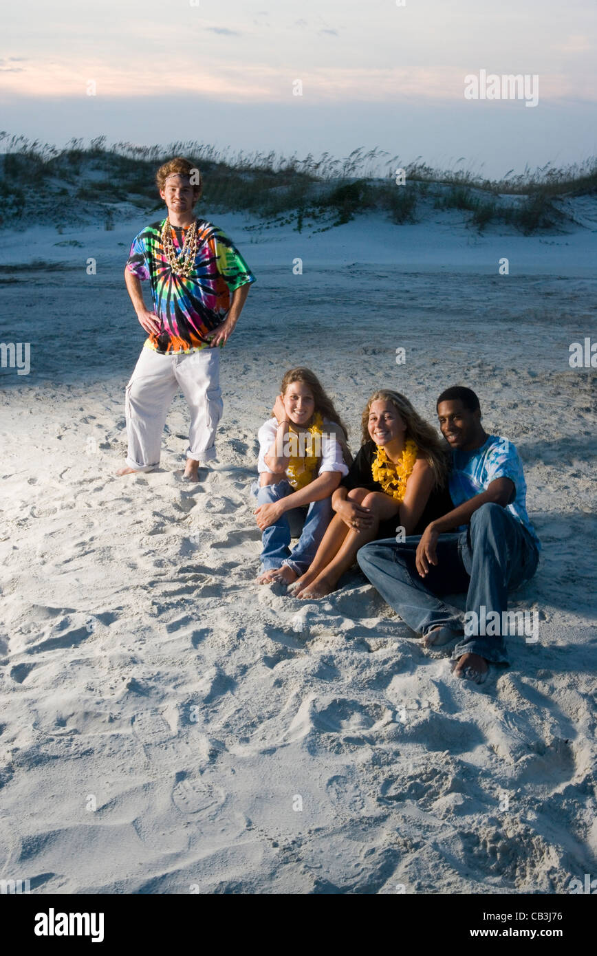 Hippies sitting on sand at beach at dusk Stock Photo - Alamy