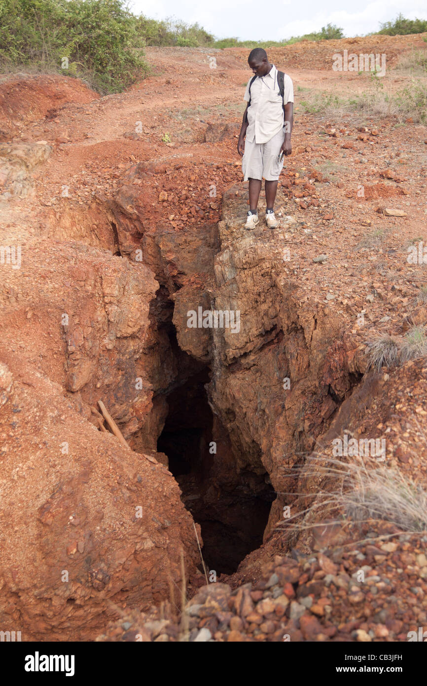 Kenyan geologist standing over mine shafts at historic Macalder copper ...