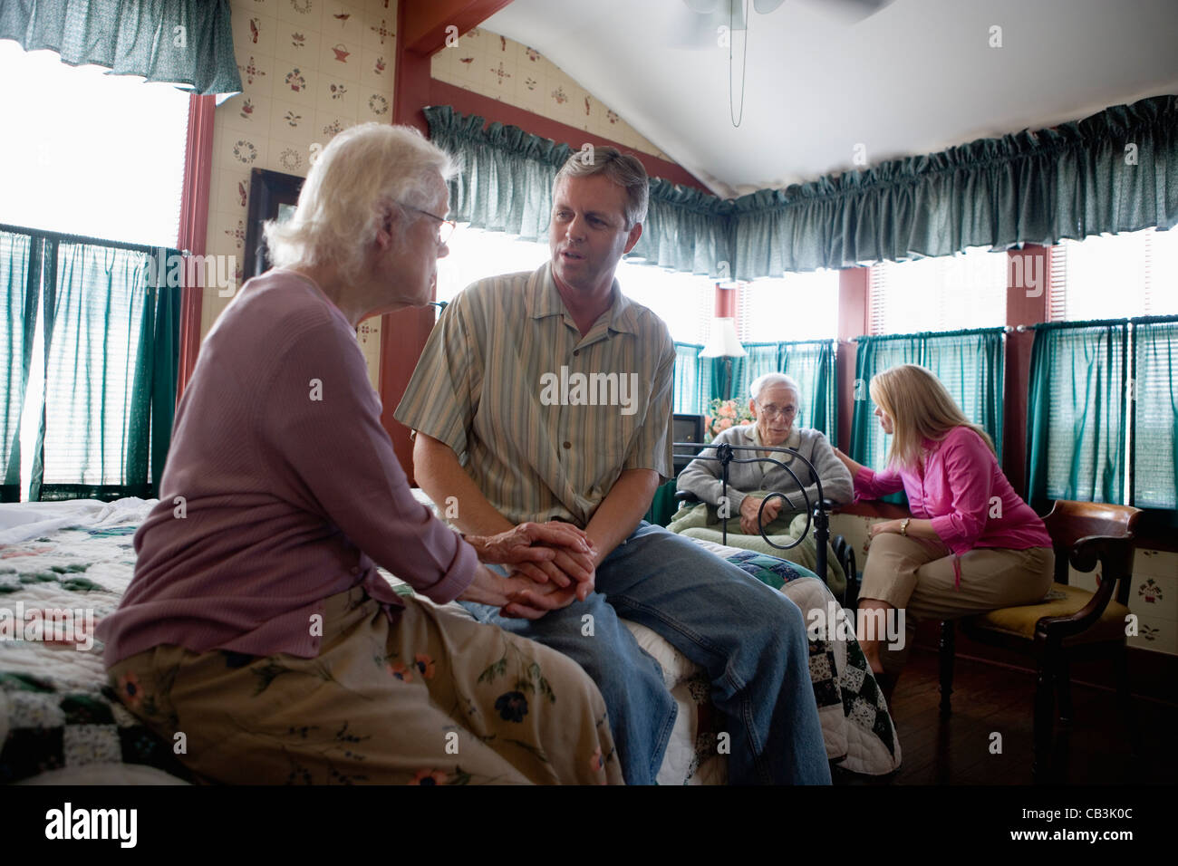 Adult children visiting and comforting senior parents in bedroom Stock ...
