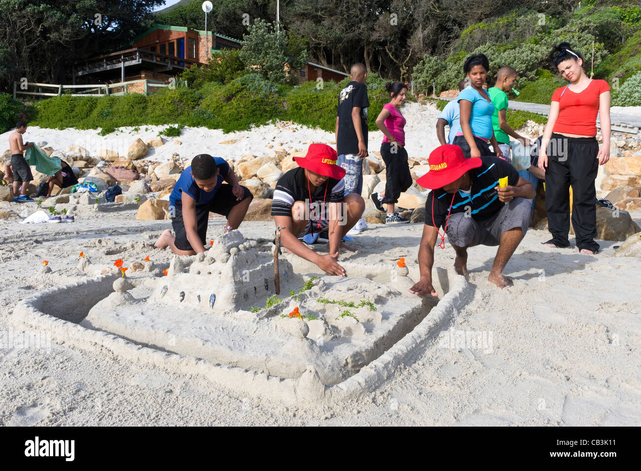 Members of a lifeguard building a sandcastle on Llandudno beach Cape ...