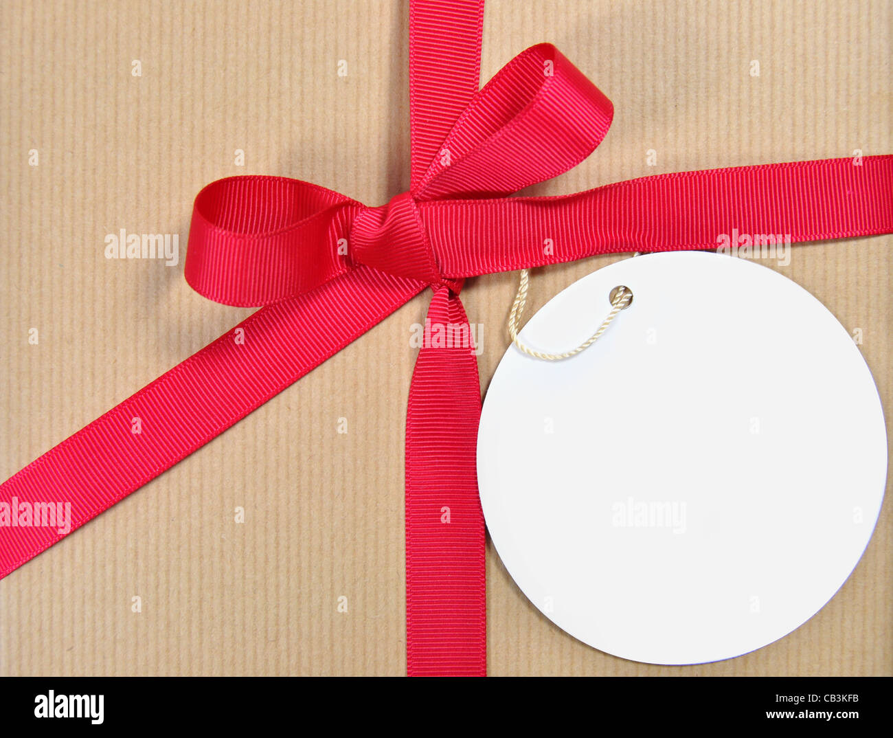 Present tied with a ribbon bow with a blank gift tag attached Stock ...