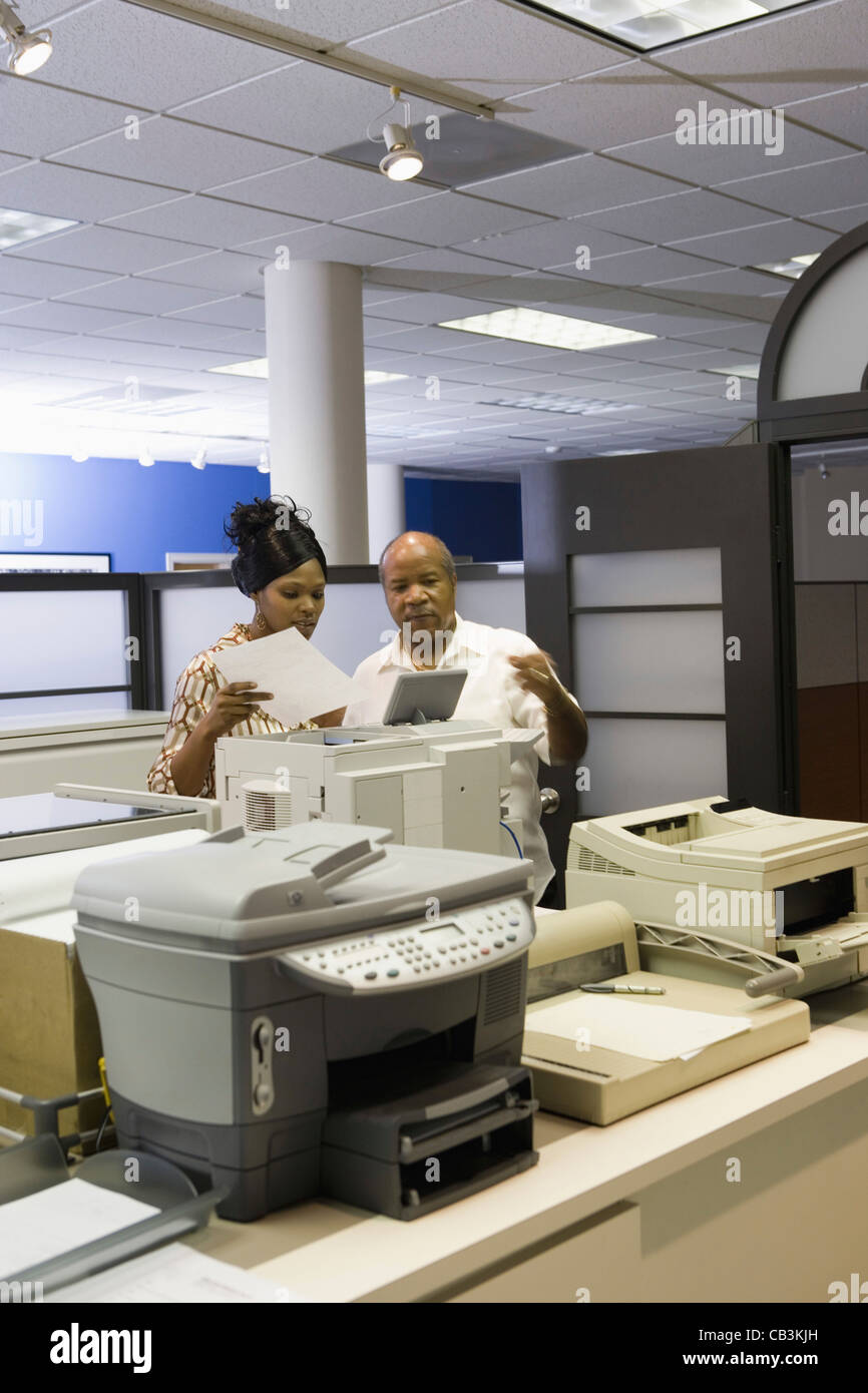 Co-workers using office equipment Stock Photo - Alamy