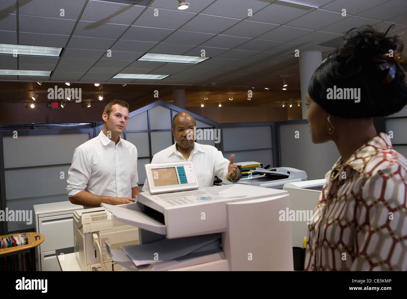 Office workers talking by photocopier Stock Photo - Alamy