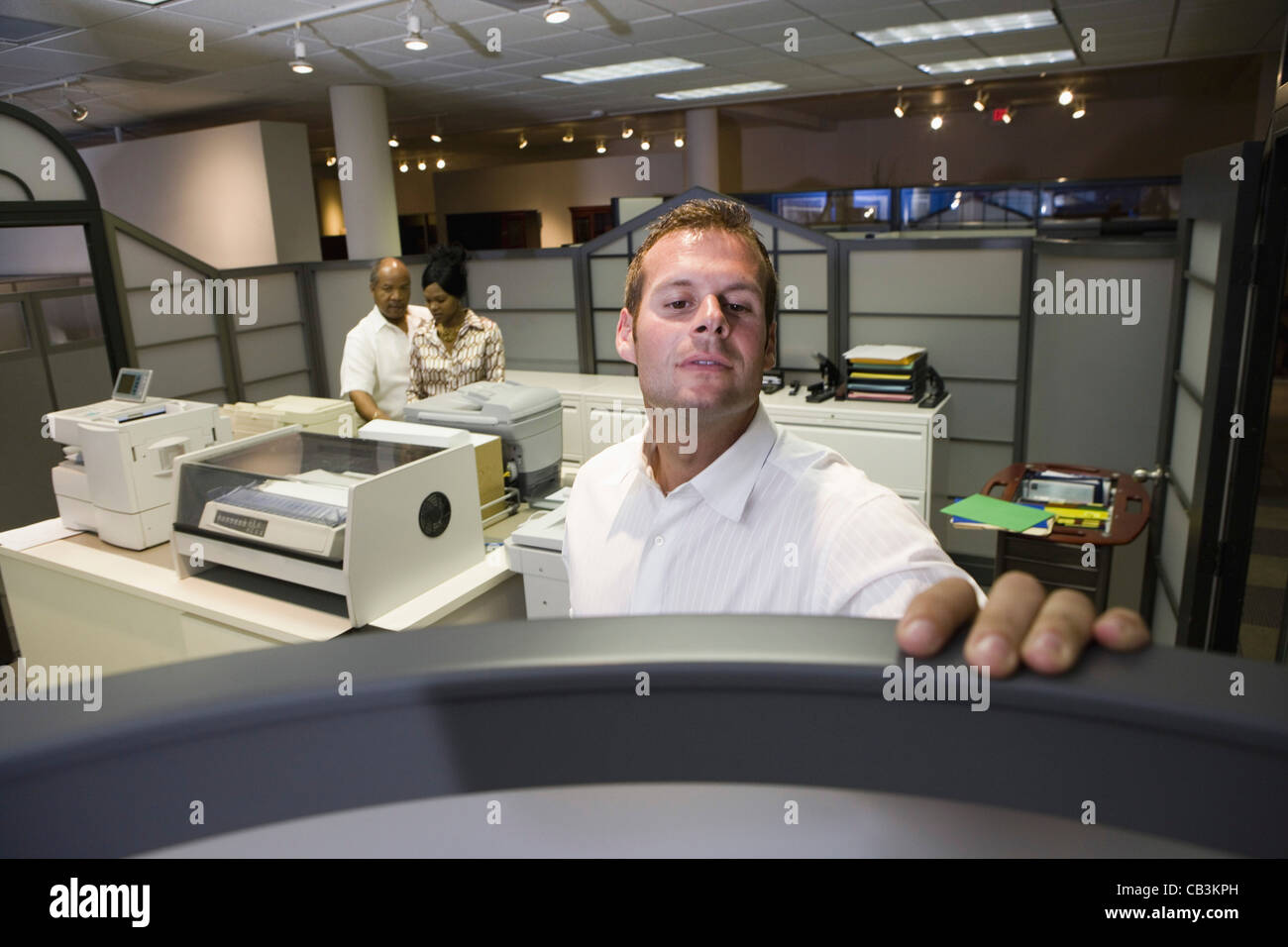 Office worker looking over cubicle wall near office equipment Stock ...