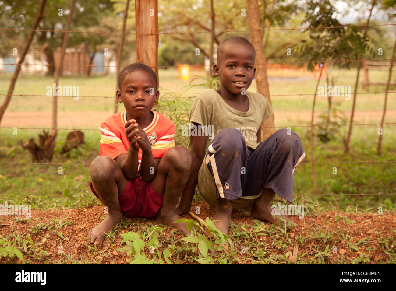 Two young Kenyan boys sit by the road side Stock Photo - Alamy