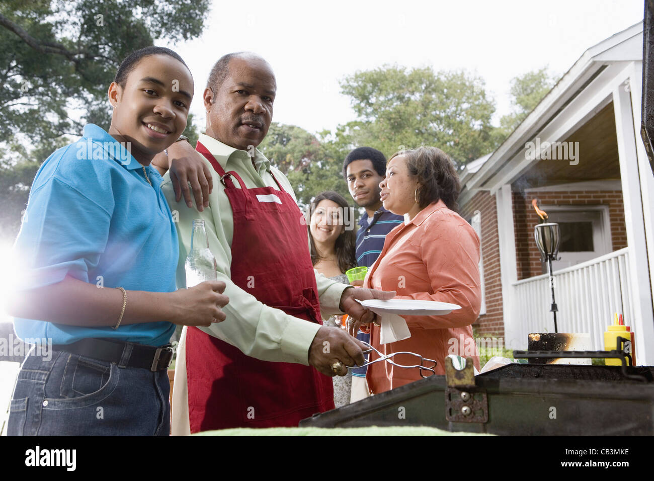 Family and friends enjoying backyard cookout Stock Photo - Alamy