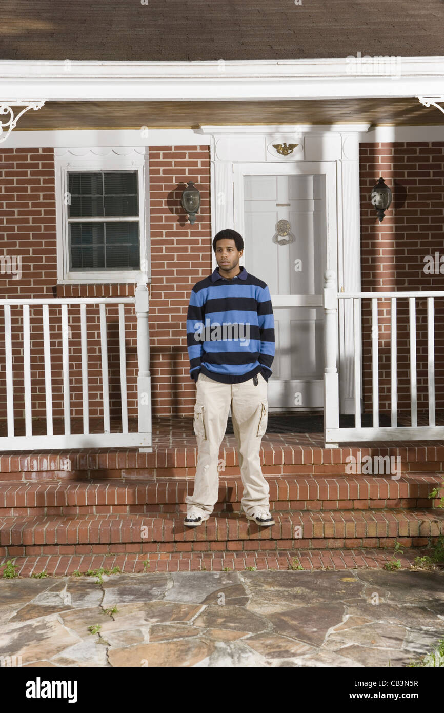 Portrait of a young man standing on front porch of house Stock Photo ...