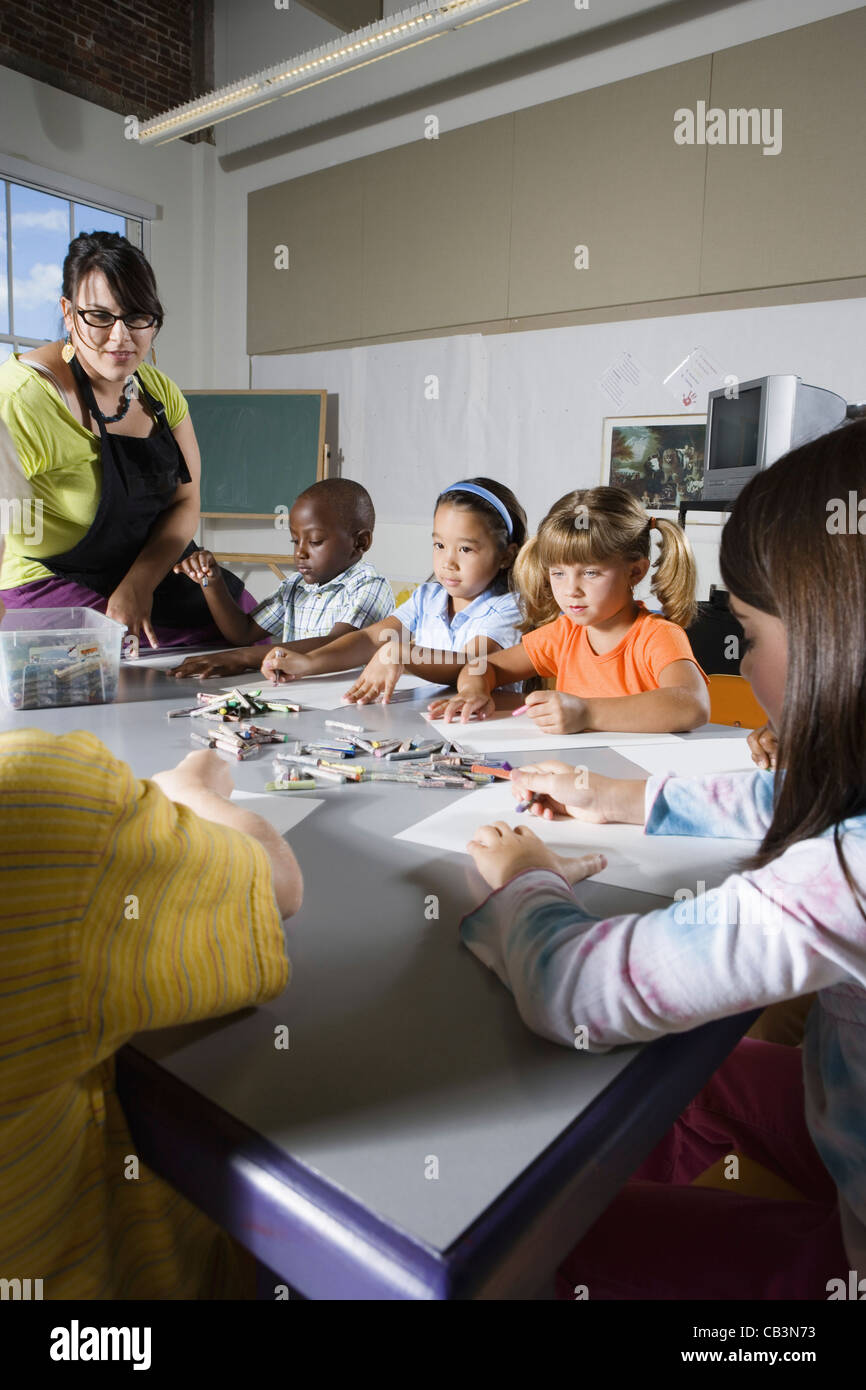 An art teacher teaching young students in art class Stock Photo - Alamy