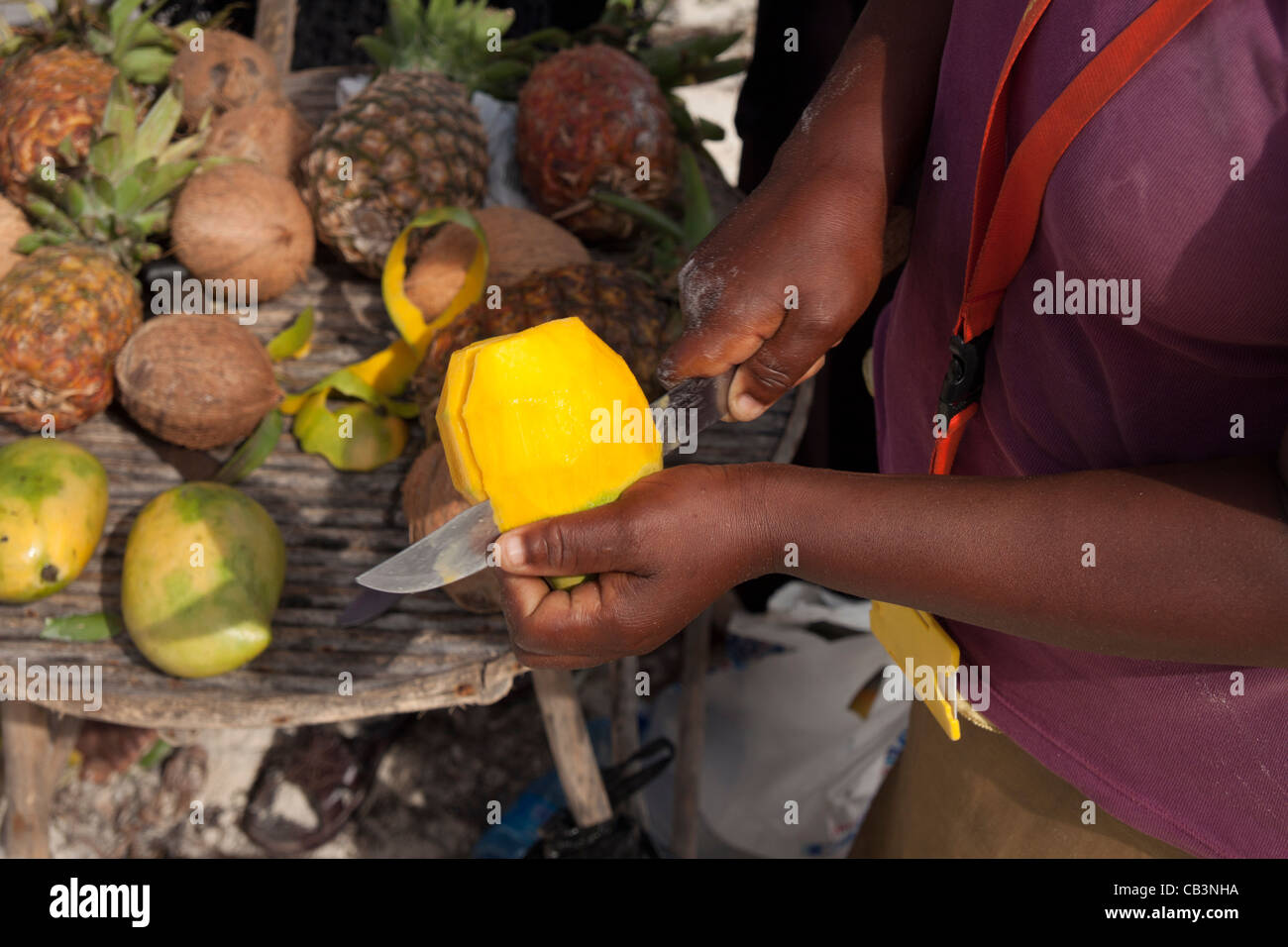 A woman serves fresh mango's to tourists on Bamburi Beach, Mombasa ...