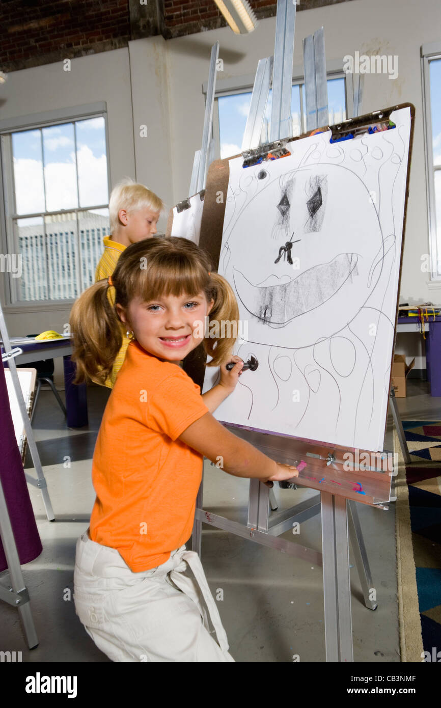 Young girl drawing on easels in art class Stock Photo - Alamy