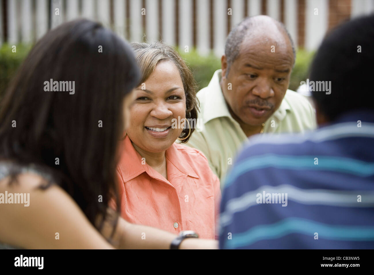 Mature couple conversing with others in foreground Stock Photo - Alamy