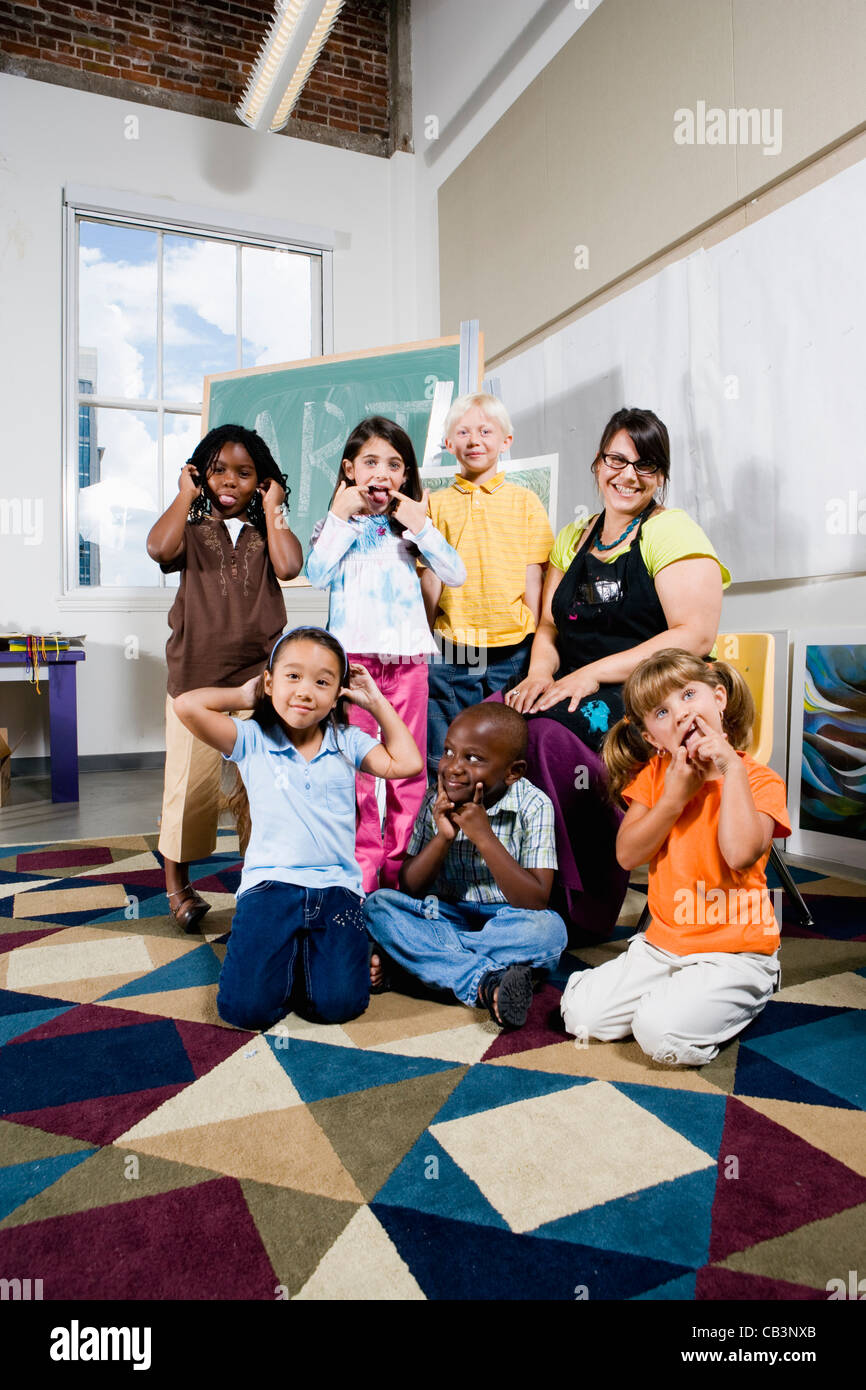 Portrait of an art teacher posing with her students making funny faces ...