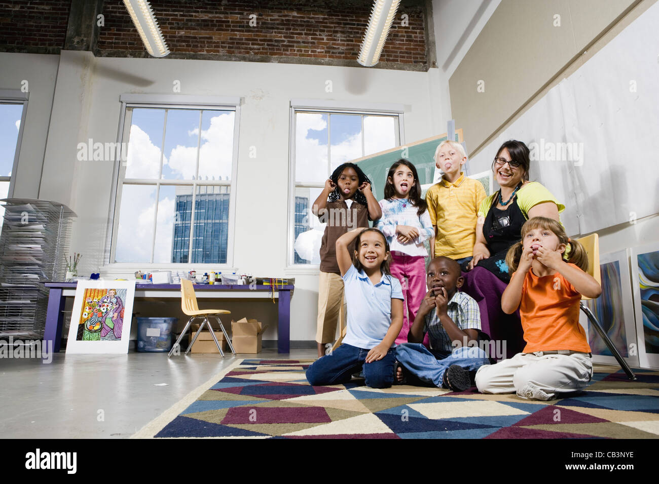 Portrait of an art teacher posing with her students making funny faces ...