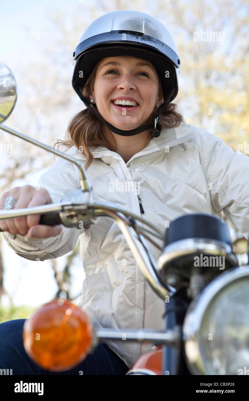 Smiling teenage girl sitting on motorcycle Stock Photo - Alamy